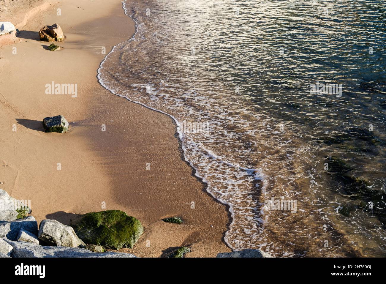 Sea water wave hangover on a quiet brown sand beach shore landscape ...