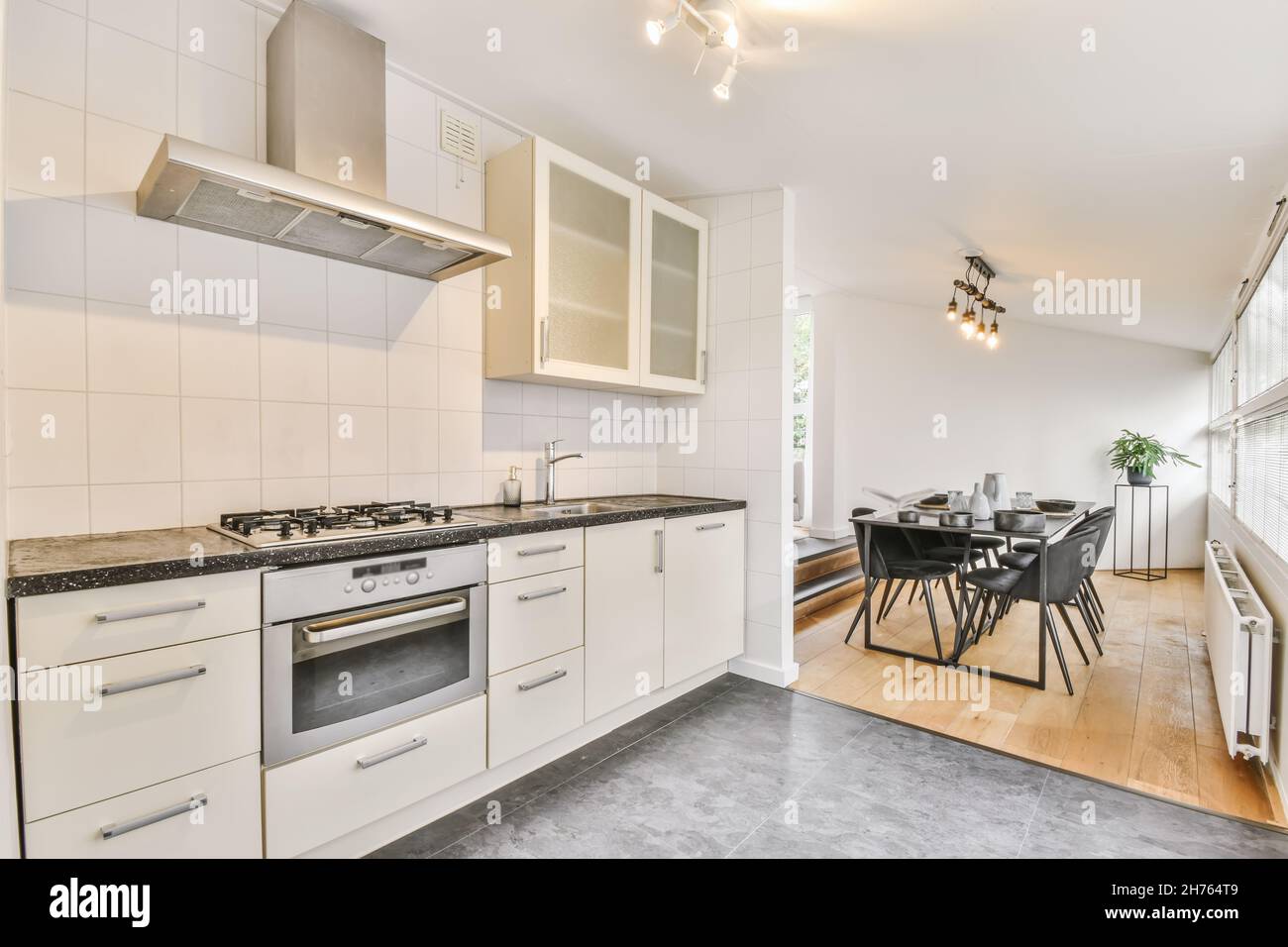 Interior of the stylish bright kitchen with dining room in the ...