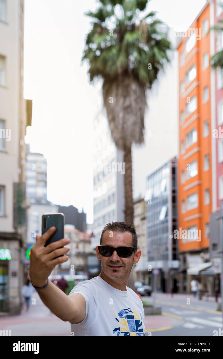 Male taking a selfie with sunglasses and a palm tree in the background ...