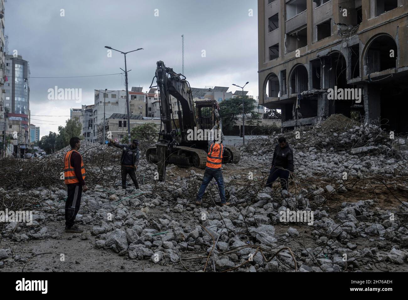 Palestinian workers remove the rubble of the Al-Jawhara Tower in the Al ...