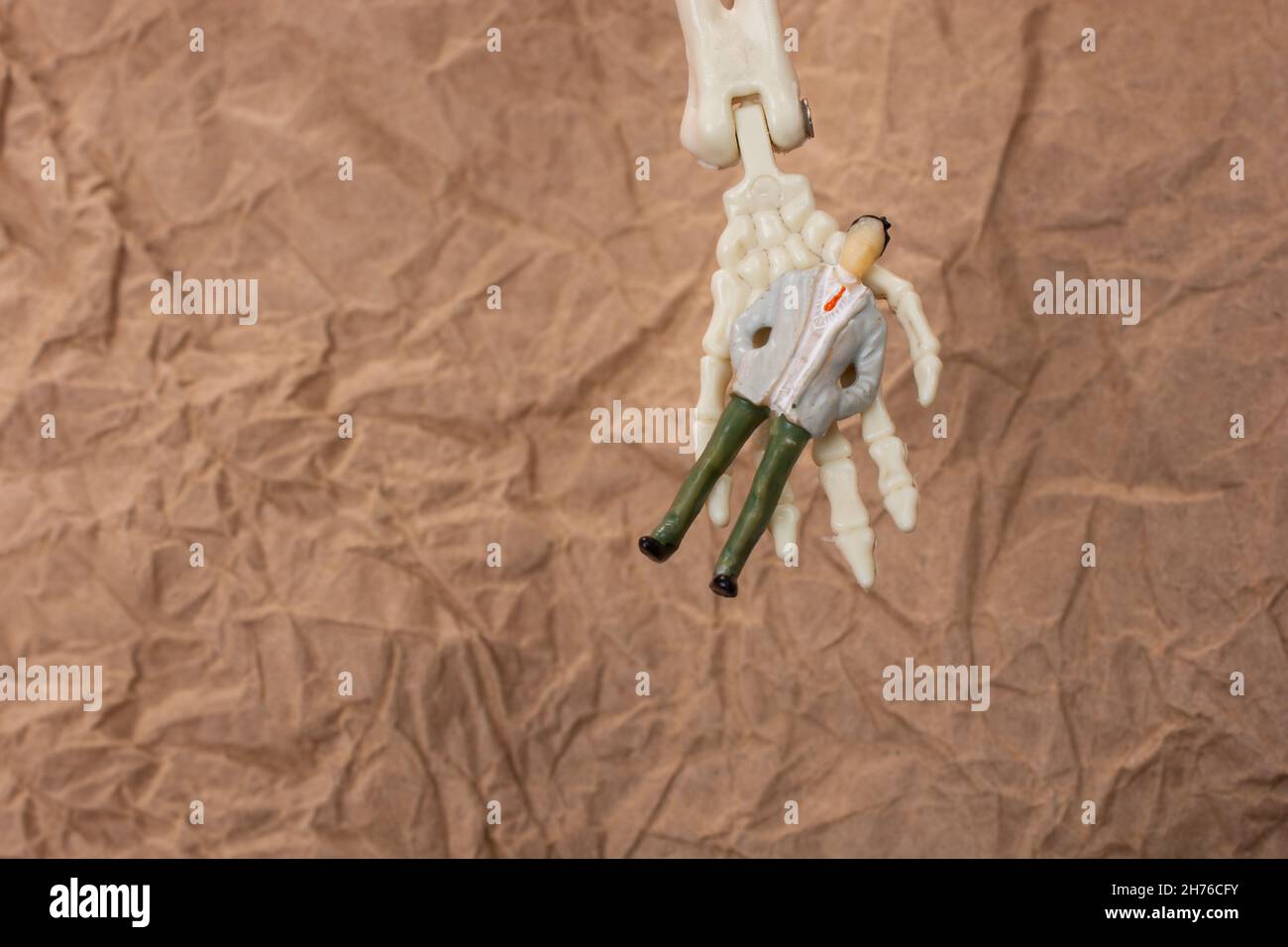 Skeleton hand pressing on figurine on red . Death concept Stock Photo ...