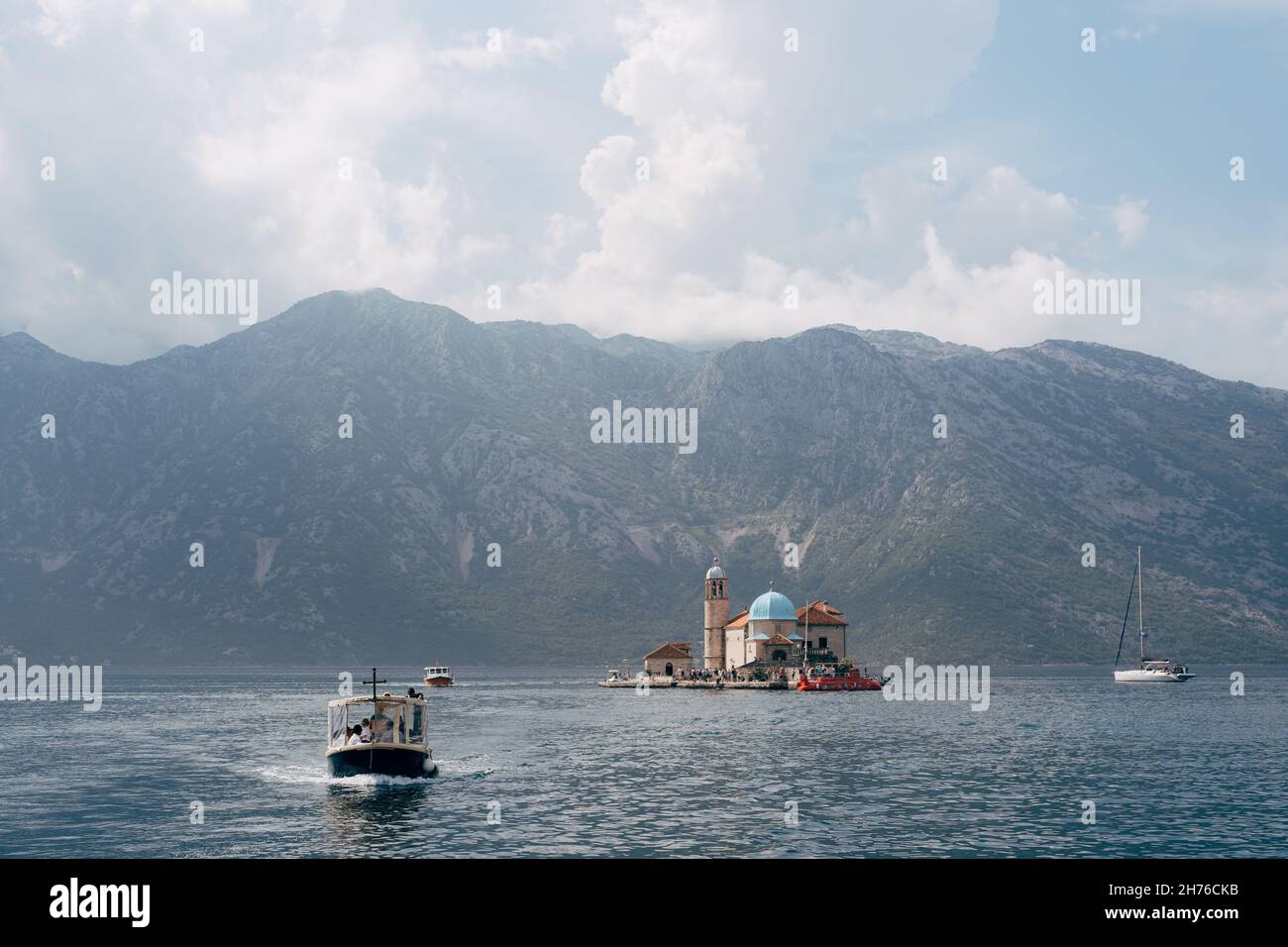 Boat sails from the Church of Our Lady of the Rocks. Montenegro Stock ...