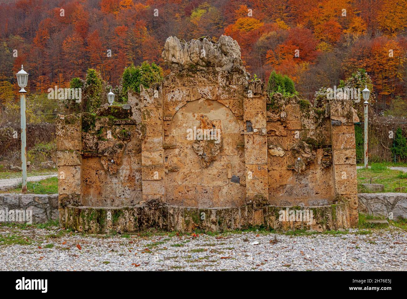Old historic fountain with rust colored stone outdoors in Serbia during ...