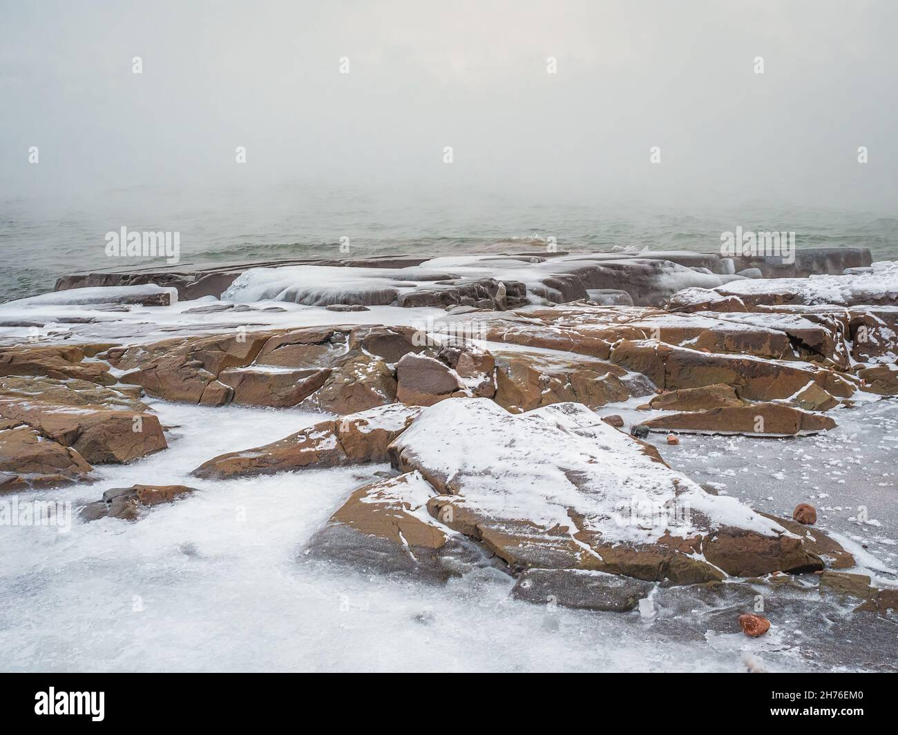 Freezing winter shoreline with rocks and icy waves Stock Photo - Alamy