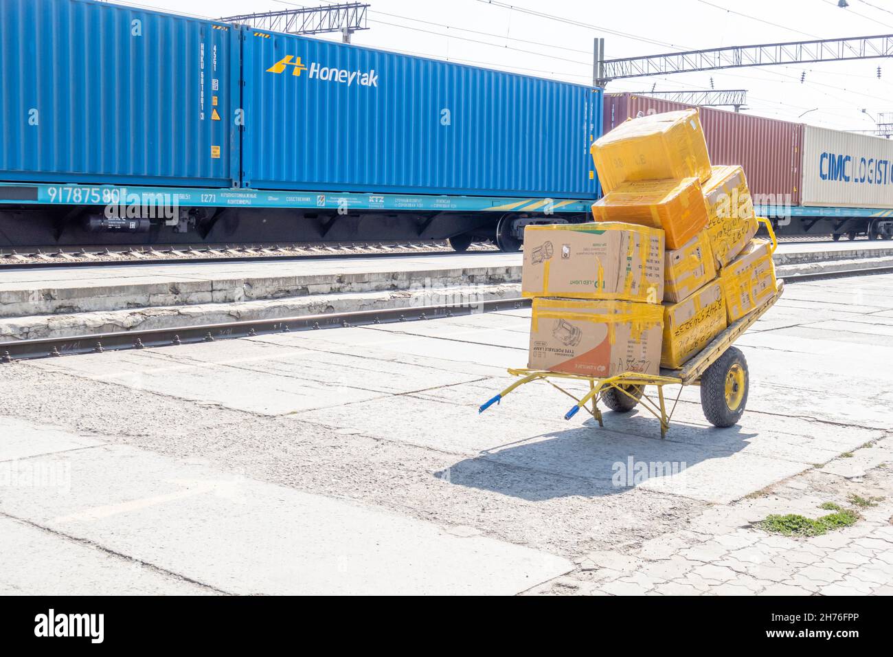 A neglected rolling cart with packaged boxes on the train platform near ...