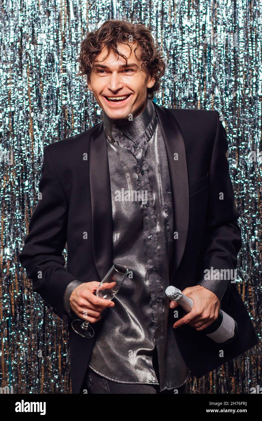 Happy tipsy man with bottle of champagne and wine glass at christmas or ...