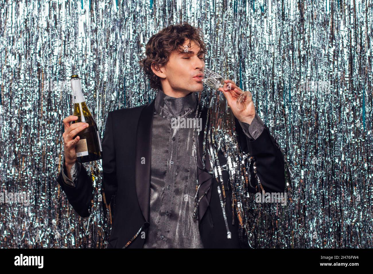 Happy tipsy man with bottle of champagne and wine glass at christmas or ...