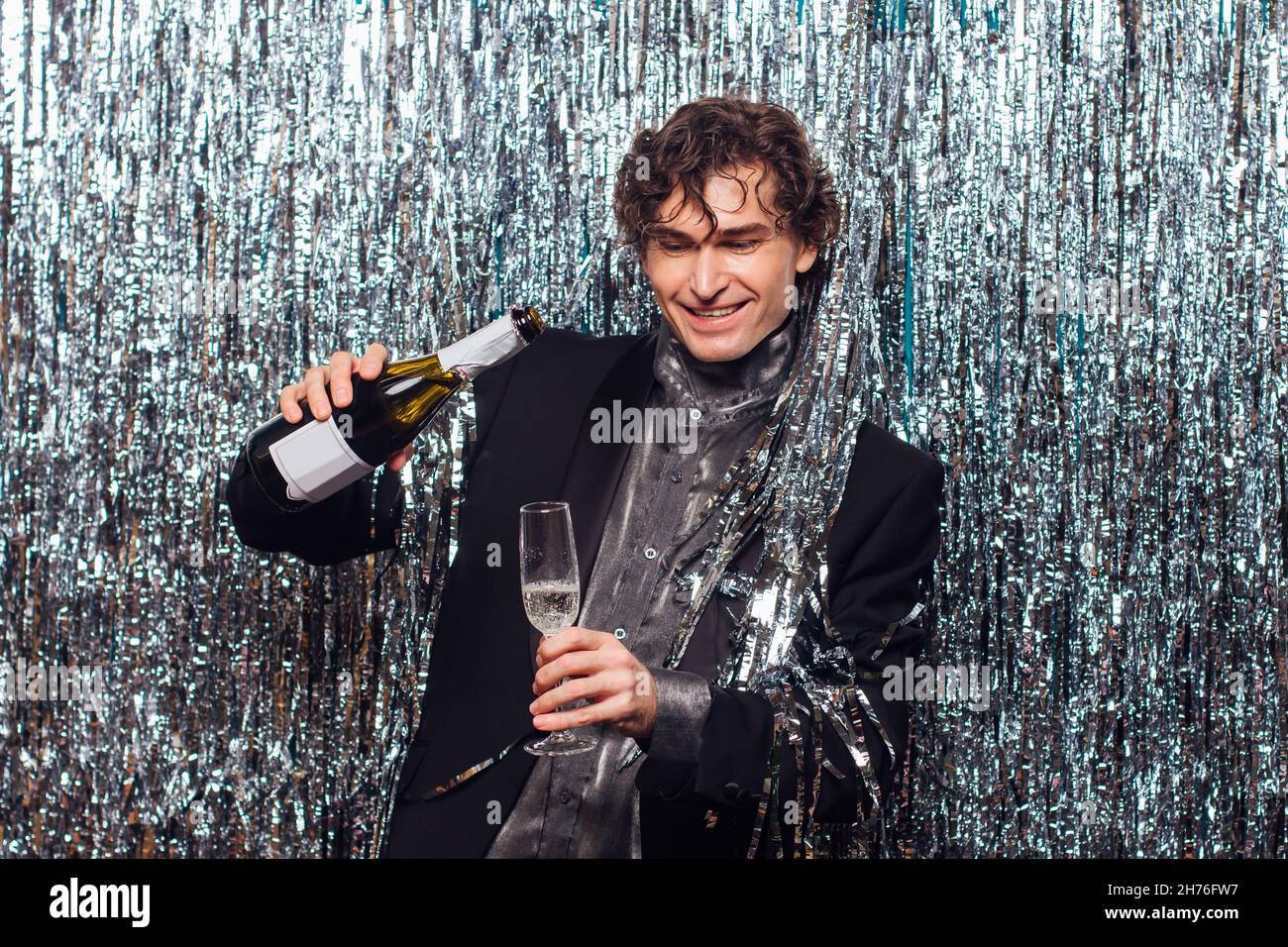 Happy tipsy man with bottle of champagne and wine glass at christmas or ...