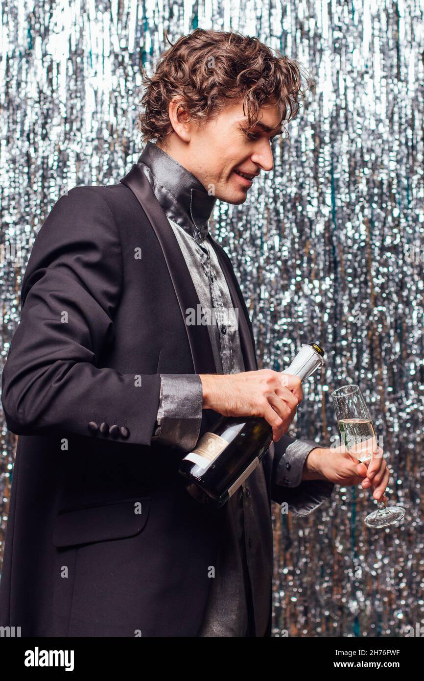 Happy tipsy man with bottle of champagne and wine glass at christmas or ...