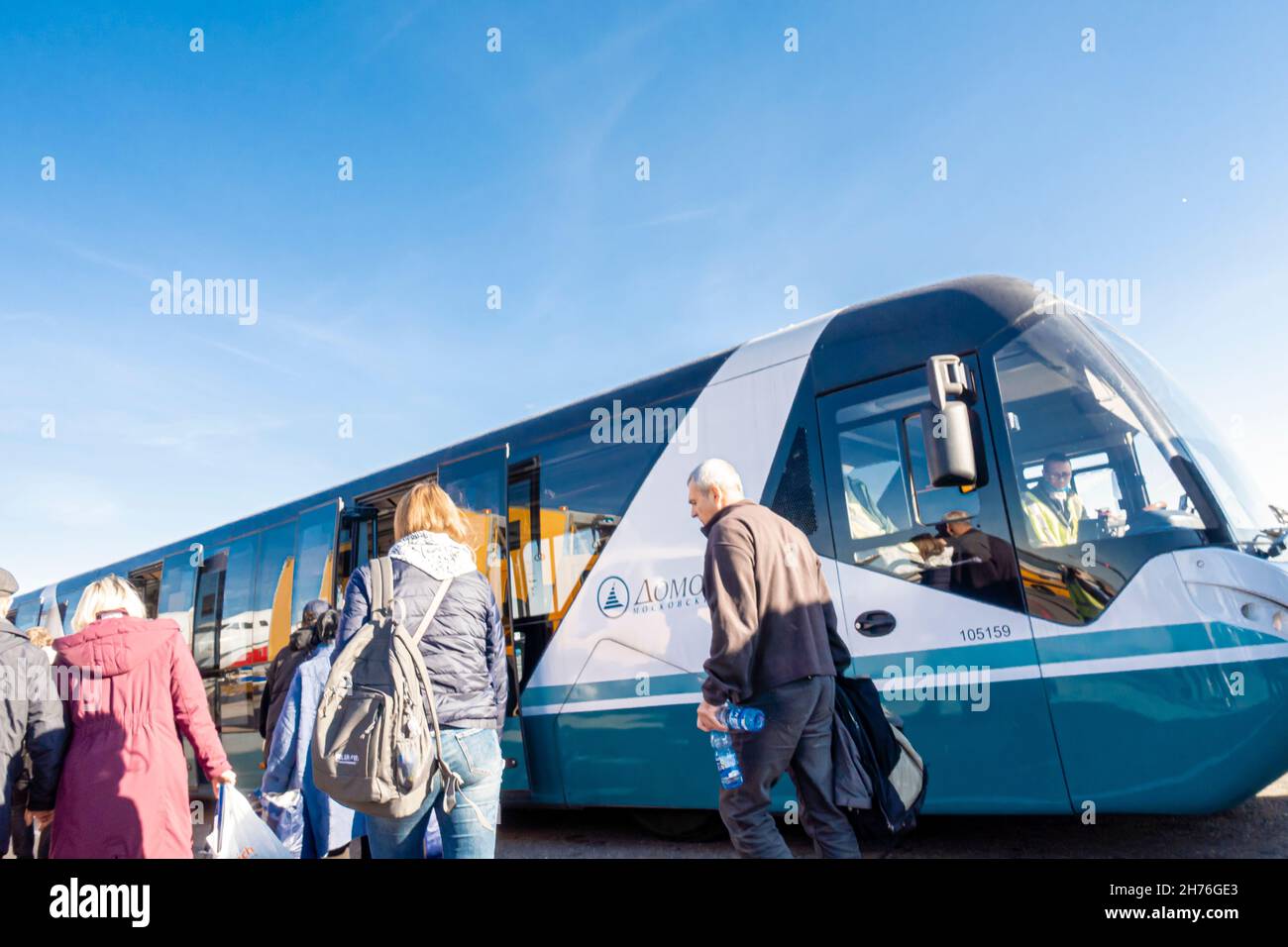 Passengers, tourists board airport shuttle bus to carry travelers to ...