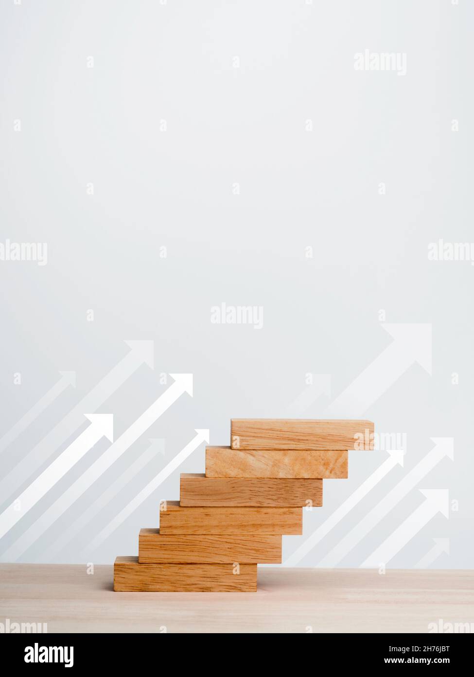 White rise up arrows with wooden blocks arranged as a steps chart on a ...