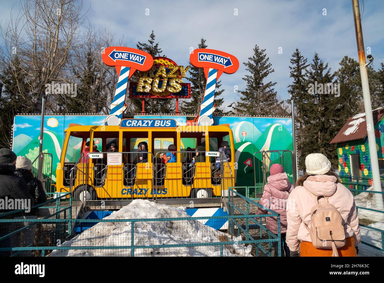 Attraction Crazy bus, with people and children riding in it, in the ...