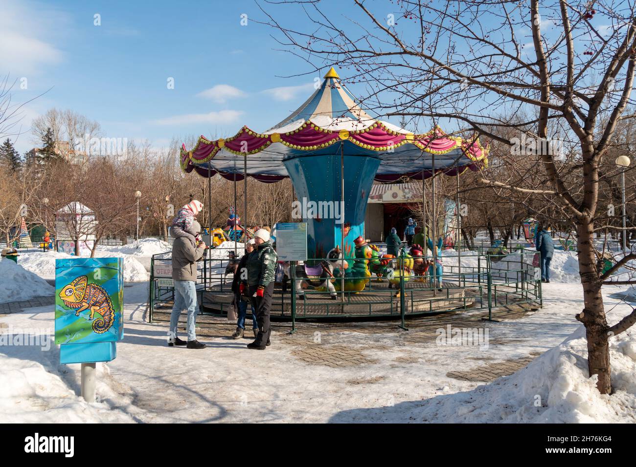 A family, along with dad with a child on their shoulders, stand near a ...