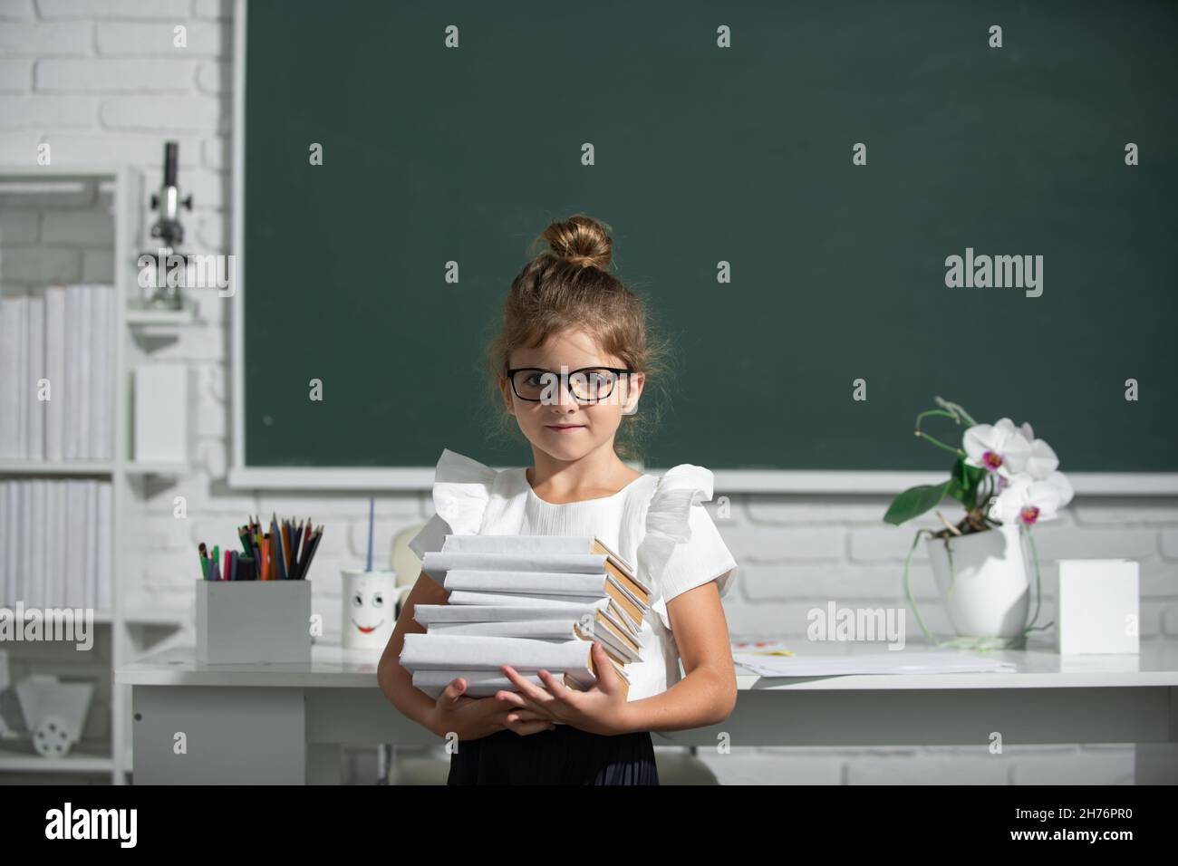 Portrait of cute, lovely, girl in school uniform in classroom. Nerd ...