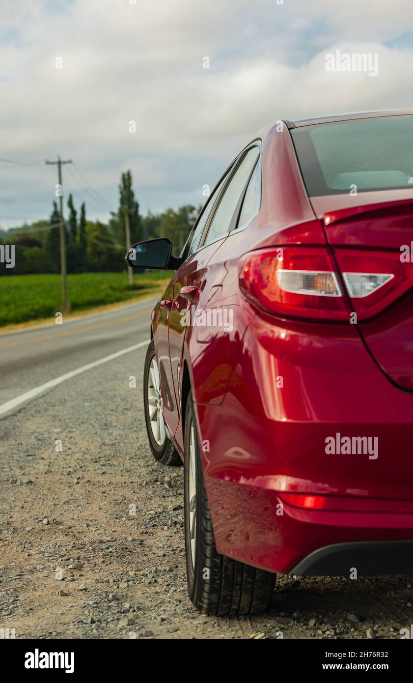 A red car on the road. Back view of modern new shiny red car parked ...
