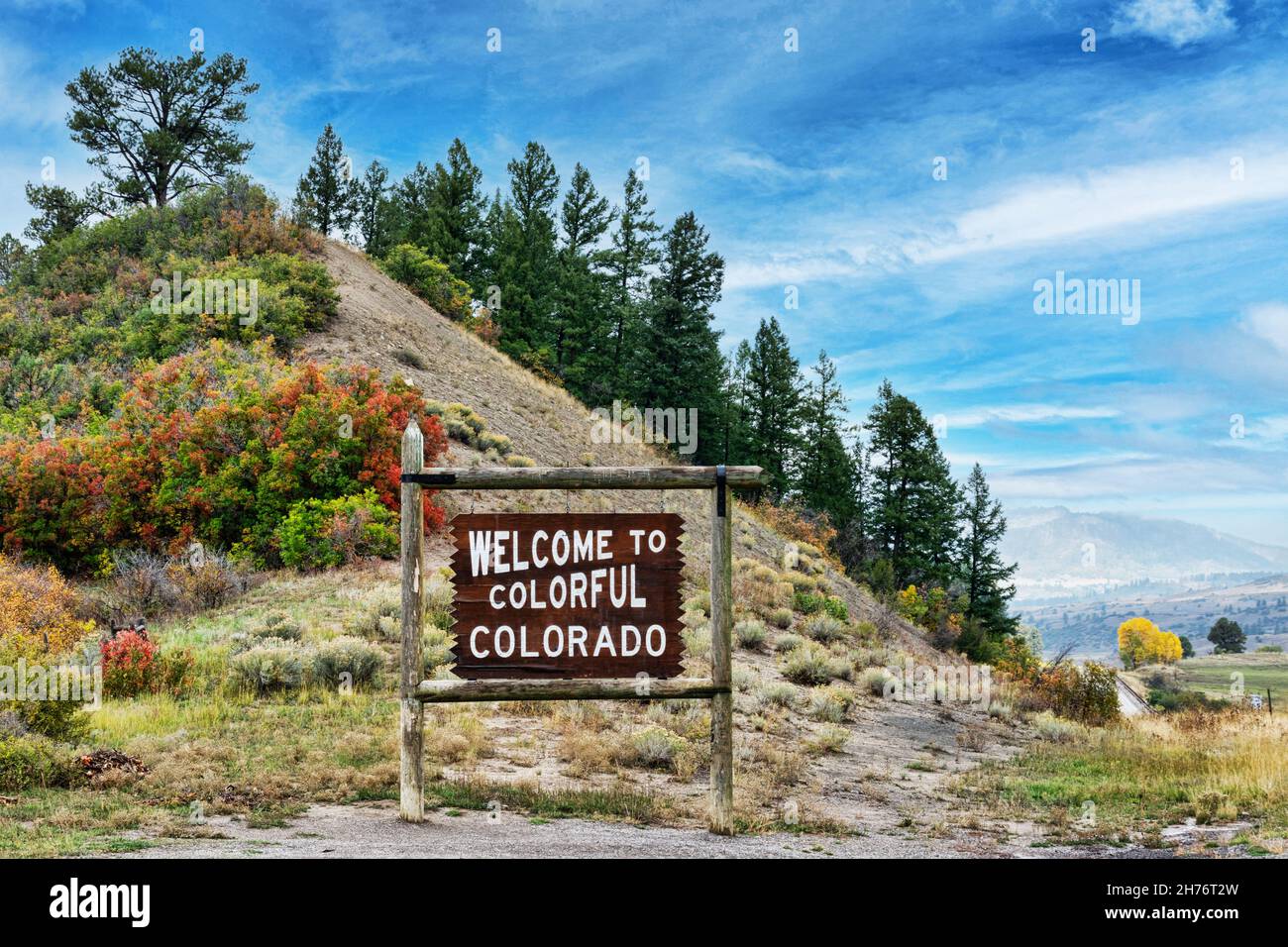 Welcome to colorful Colorado road sign on highway 84 . Green pine trees ...