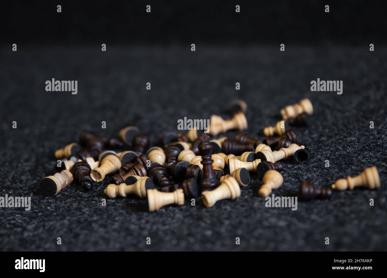 Scattered chess pieces on a blurred black background Stock Photo - Alamy