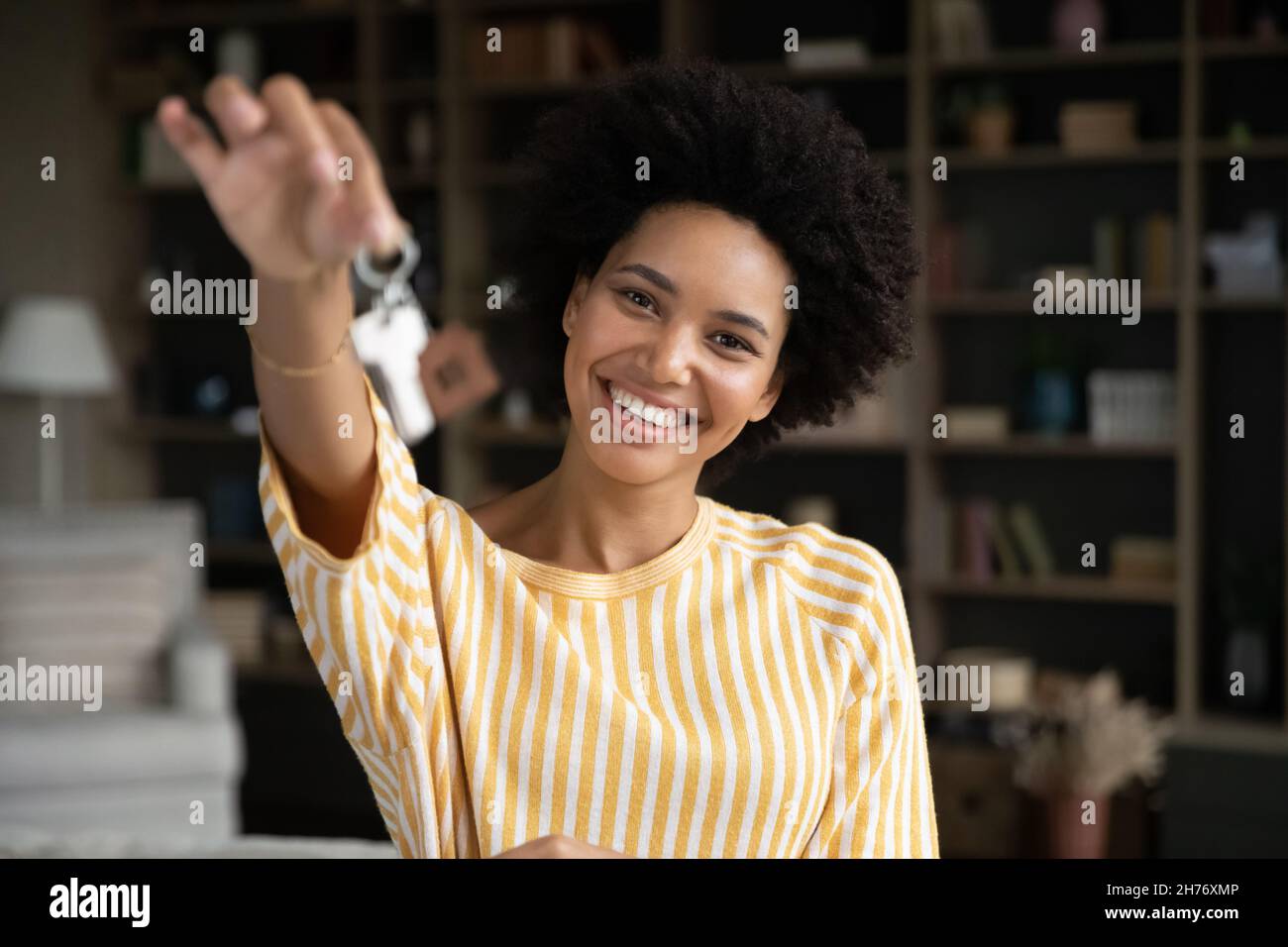 Happy joyful young African woman showing keys at camera Stock Photo - Alamy