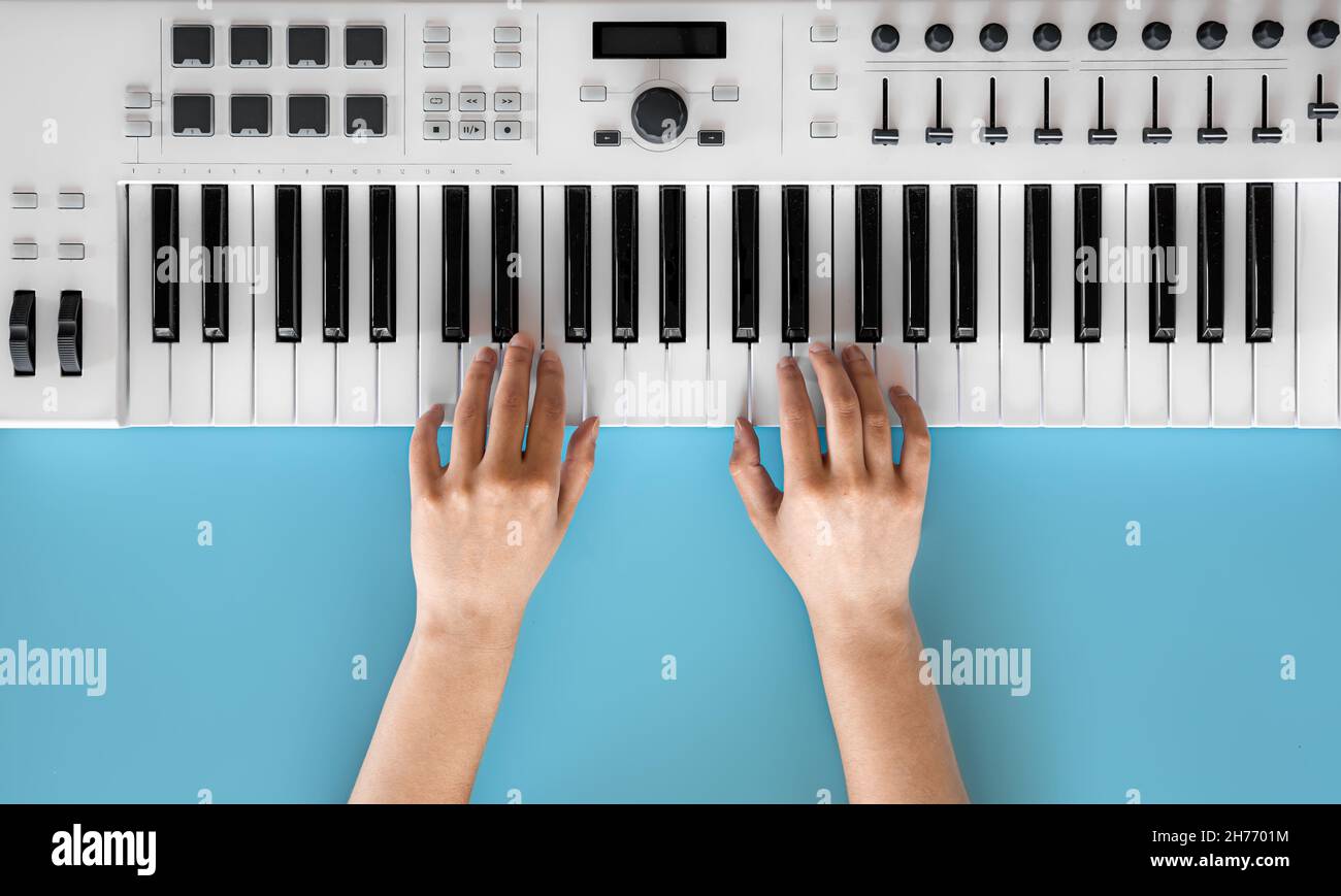 Female hands play musical keys on a blue background, top view Stock ...
