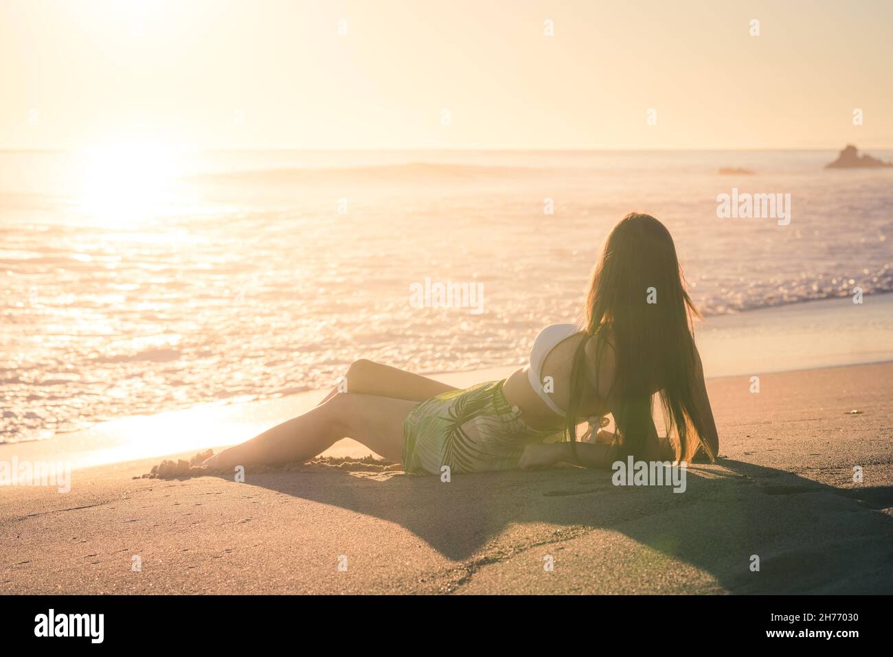 Young woman laying on the beach hi-res stock photography and images - Alamy