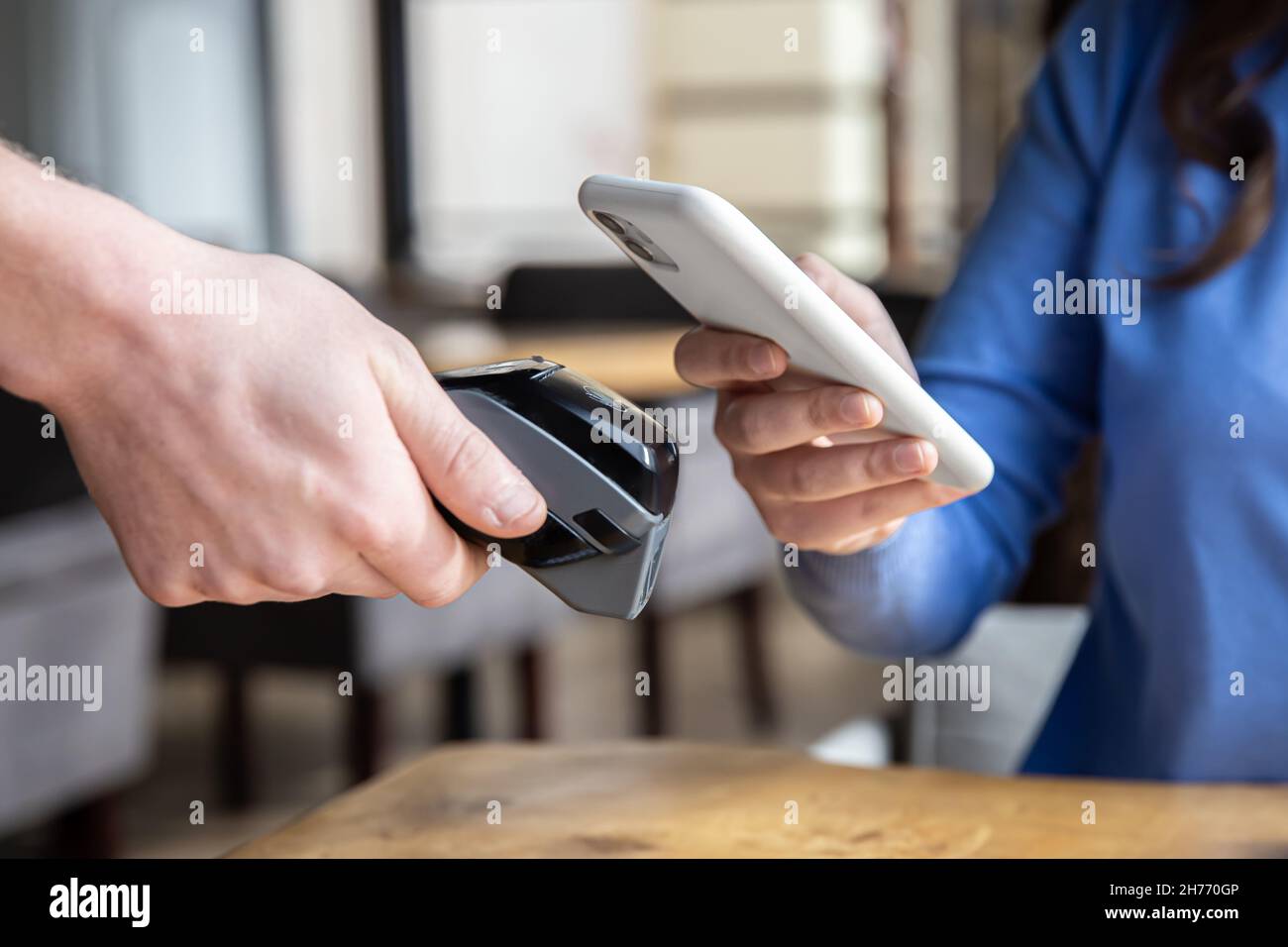 Paypass, male hands holding black pos terminal and female brings ...