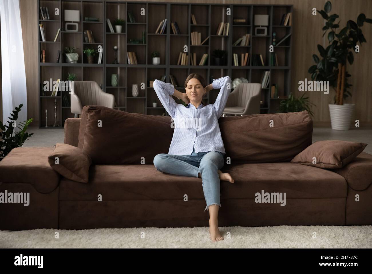Carefree woman relaxing on comfy sofa in living room Stock Photo - Alamy