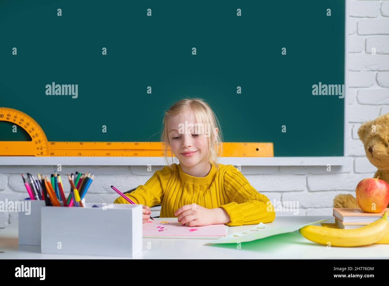 Cute little school kid girl study in a classroom. Education, learning ...