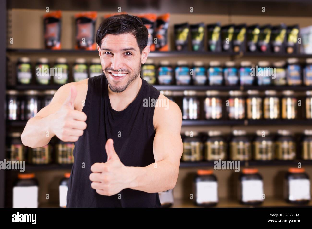 Young bodybuilder holding thumbs up in store of sport nutrition Stock ...