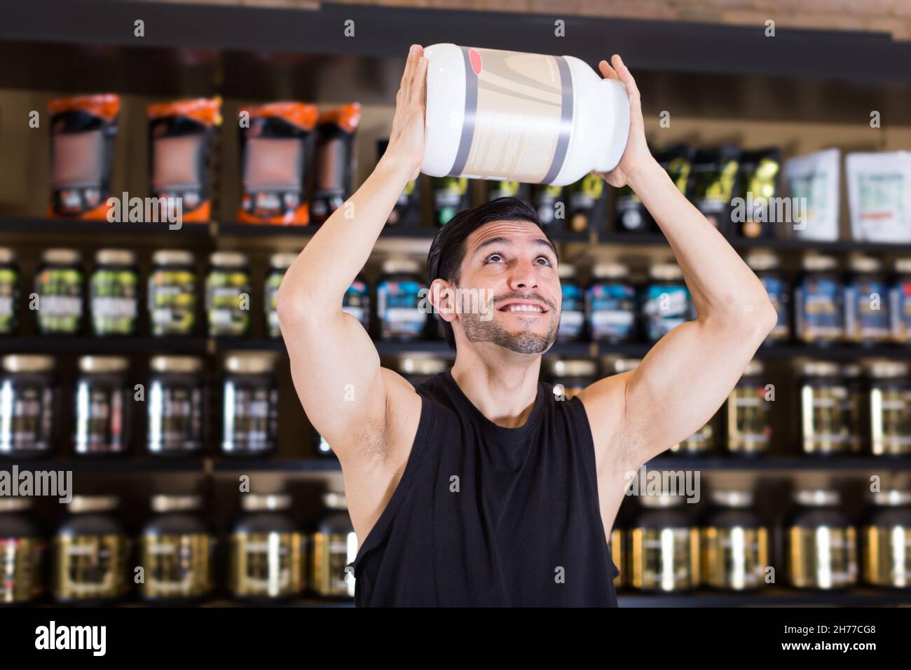 Man bodybuilder holding big pot of sport supplements over head Stock ...