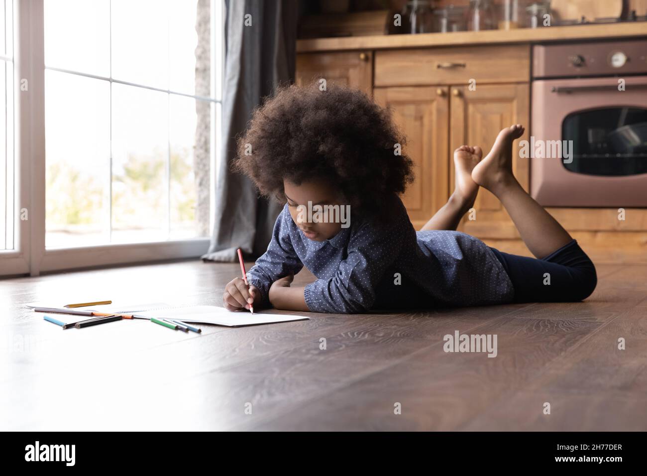 Happy African kid girl drawing pictures Stock Photo - Alamy