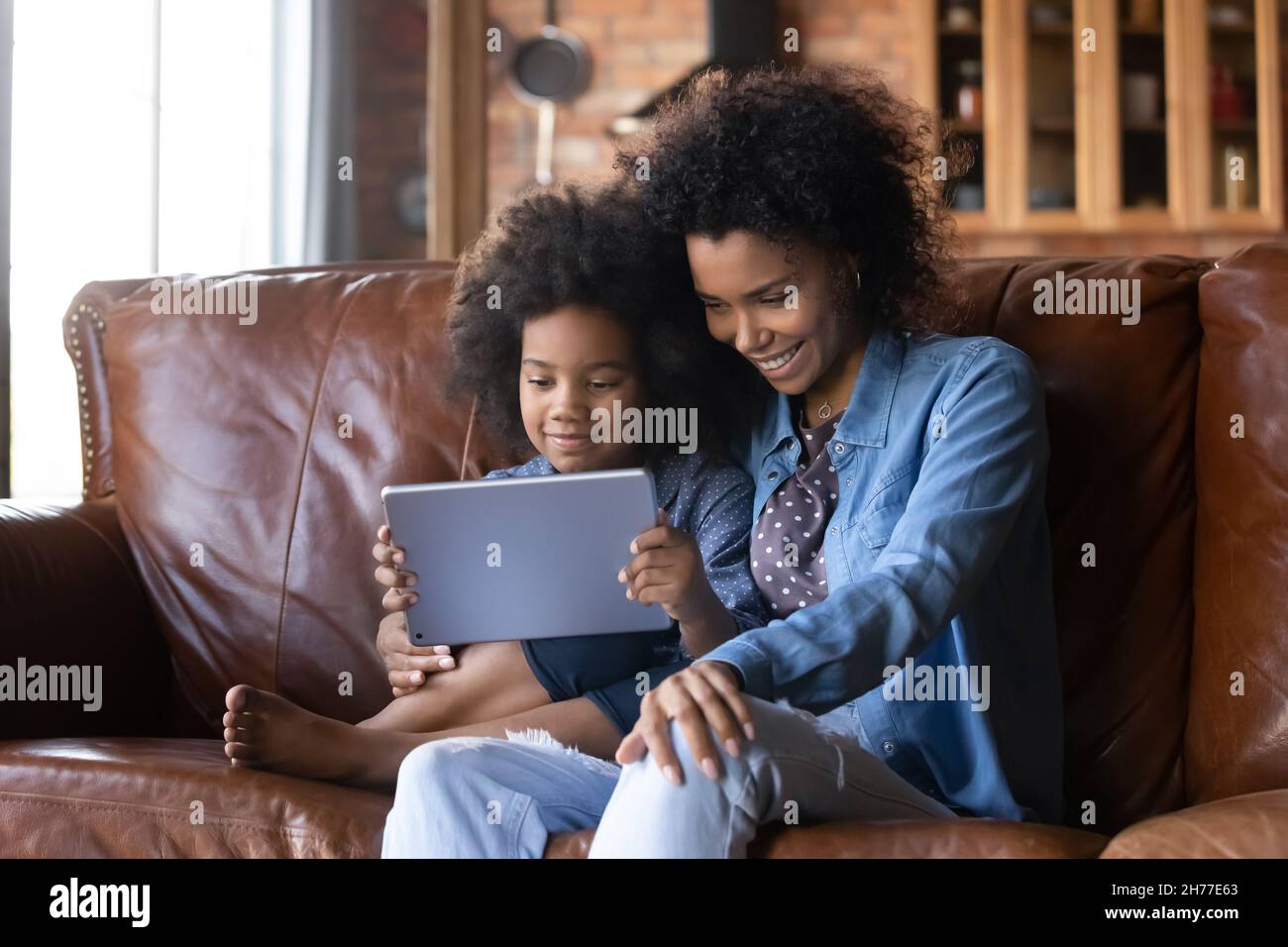 Happy African ethnicity little kid girl using tablet with mum Stock ...