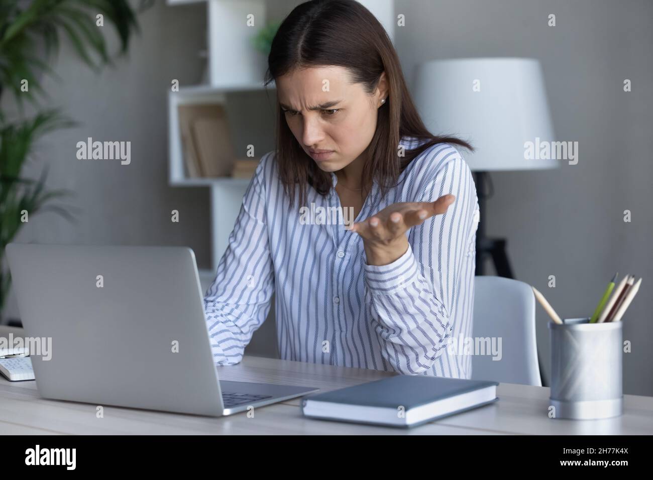 Confused young businesswoman looking at computer screen Stock Photo - Alamy