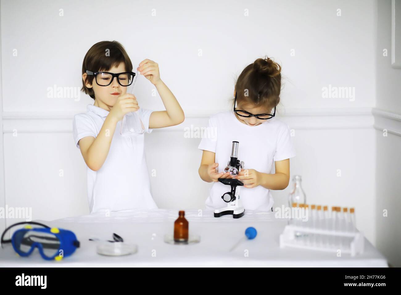 Two cute children at chemistry lesson making experiments isolated on ...