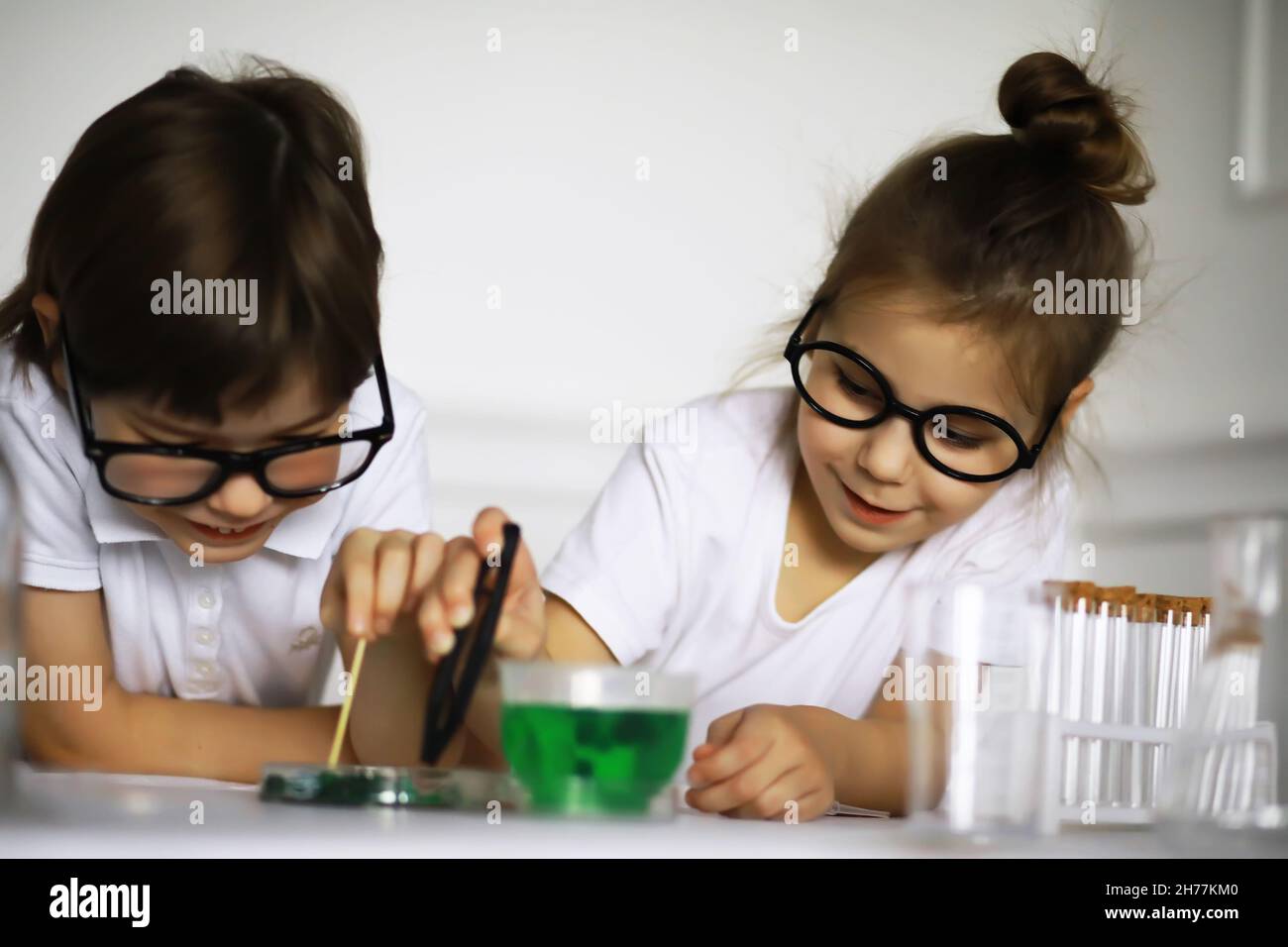 Two cute children at chemistry lesson making experiments isolated on ...
