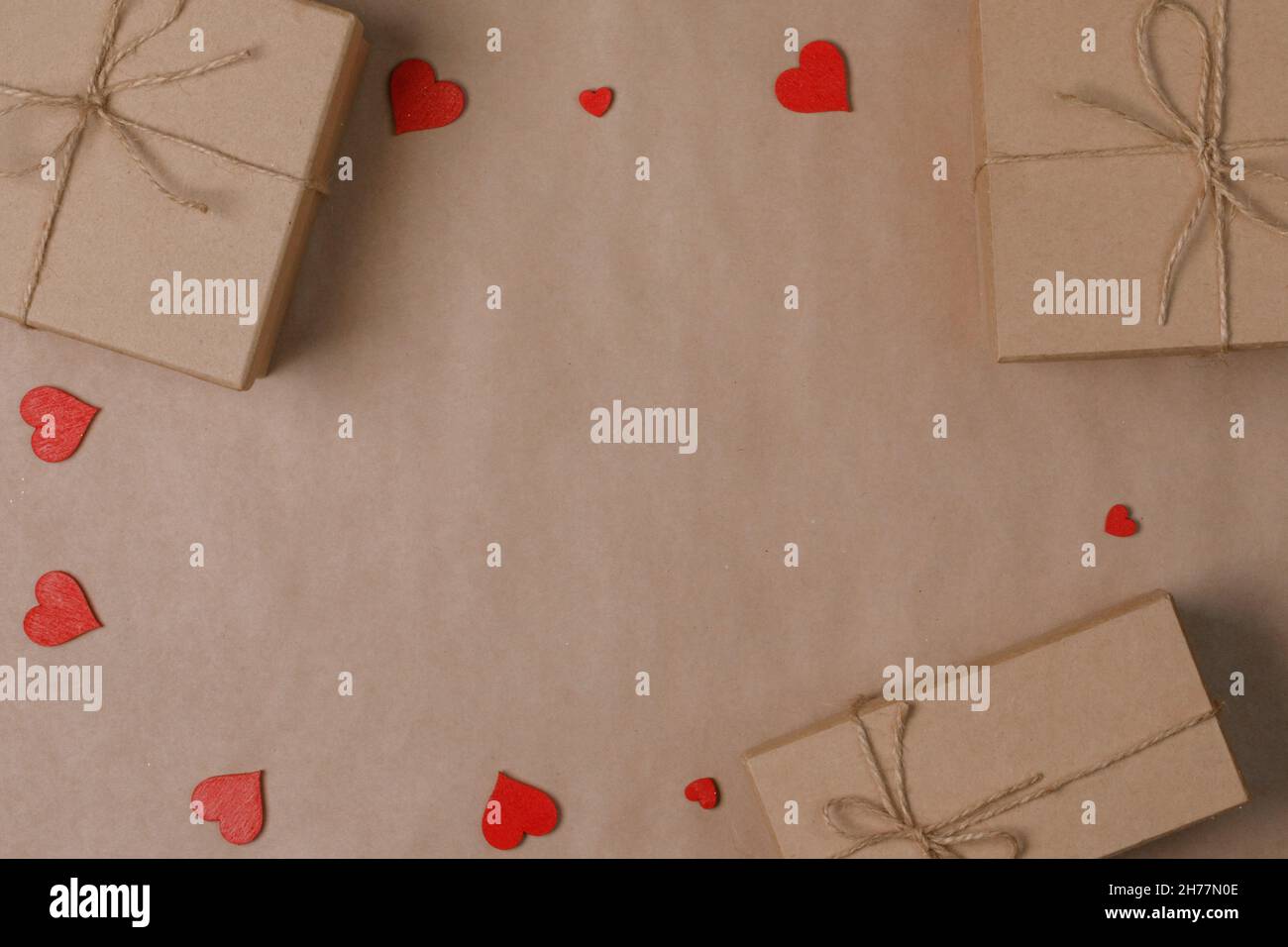 Gift boxes wrapped in brown craft paper and tied with rope with red ...