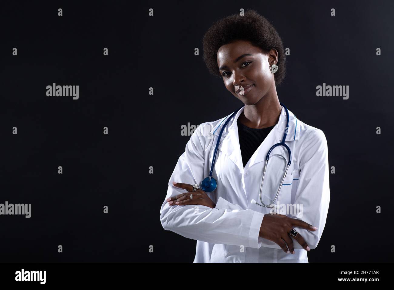 Black female doctor smiling at black background. African american woman ...