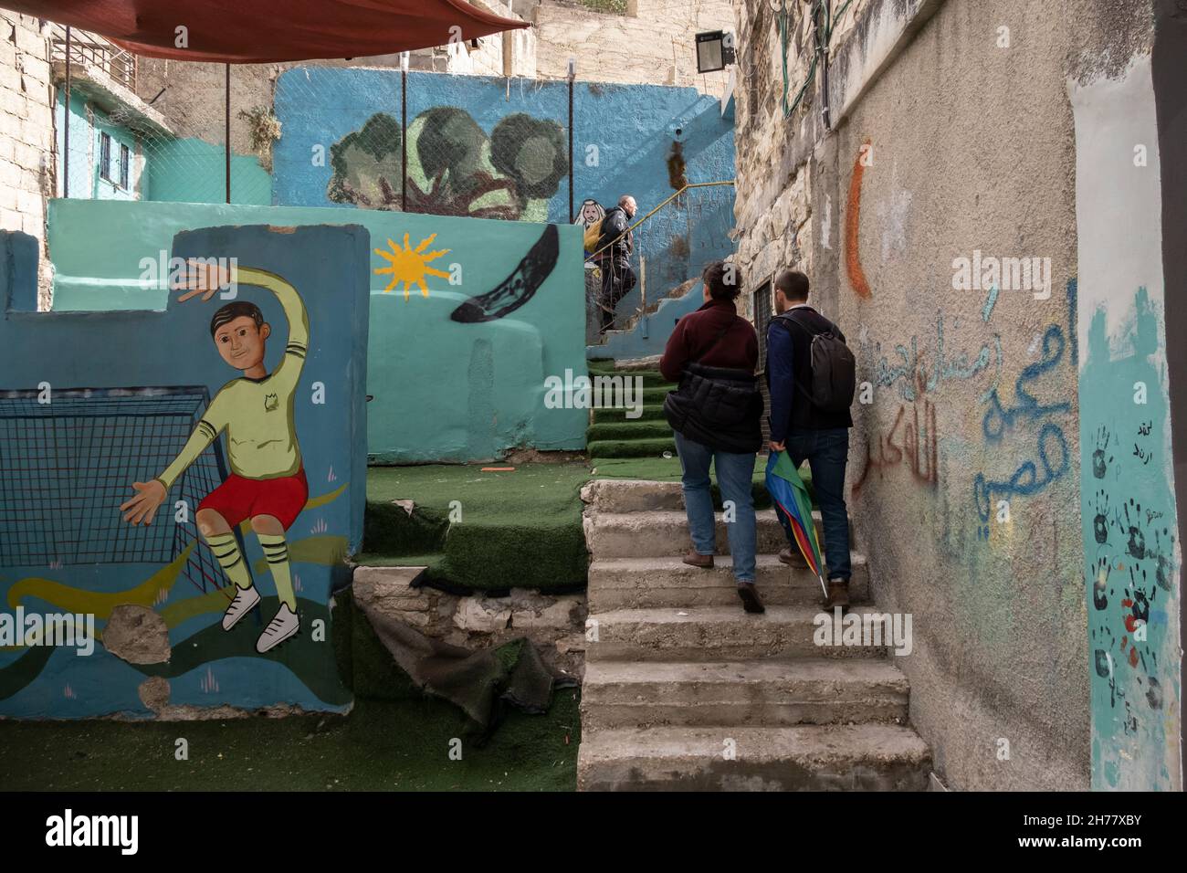 Visitors walk trough Batn Al-Hawa neighborhood in Silwan a ...