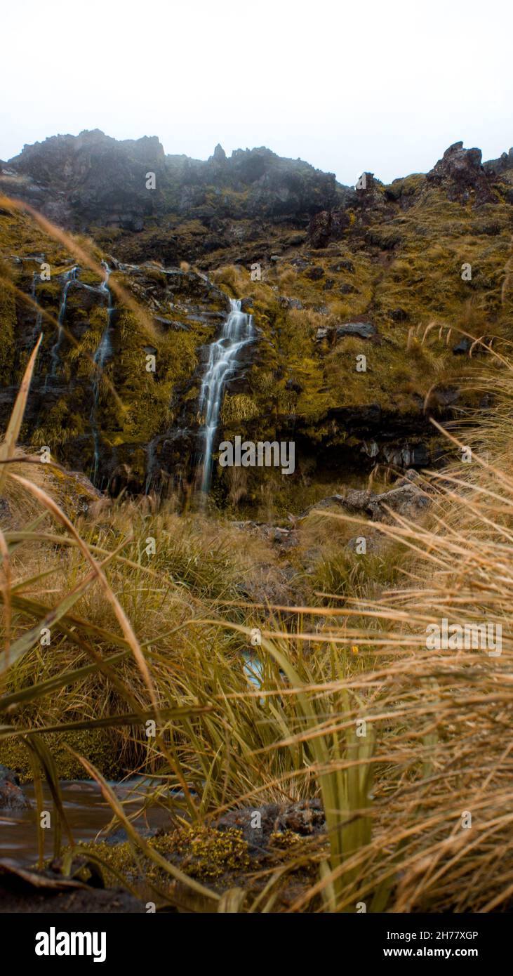 A waterfall in the background of foggy Tongariro mountains in New ...