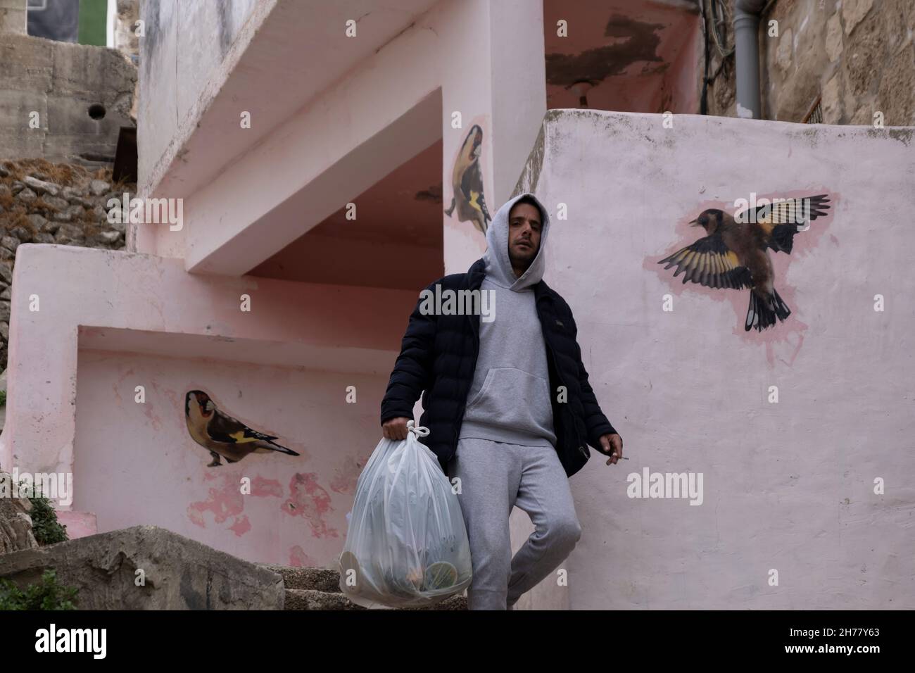 A Palestinian resident walks trough a house decorated with painted wall ...