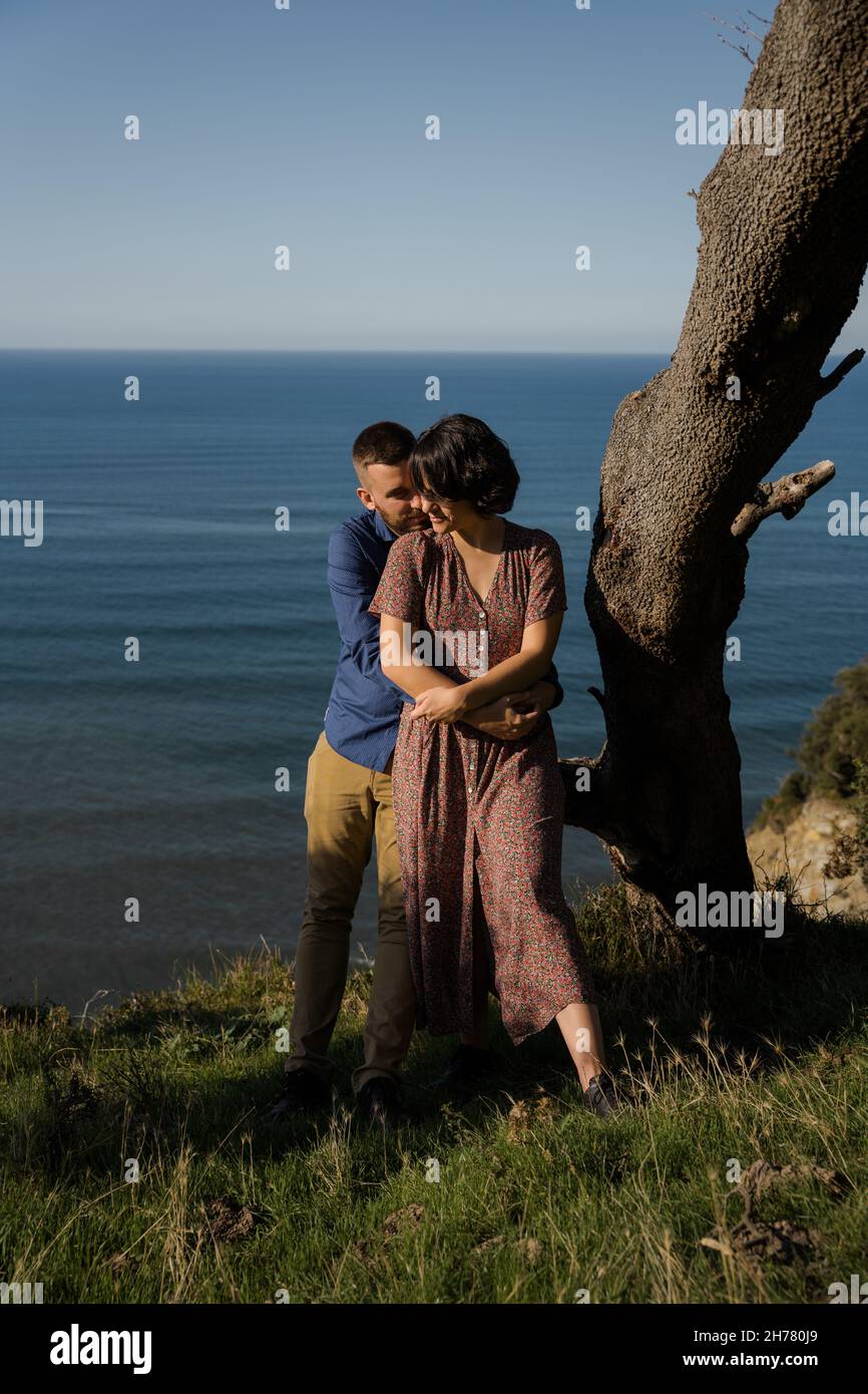 A cute young couple embracing on top of a cliff Stock Photo - Alamy