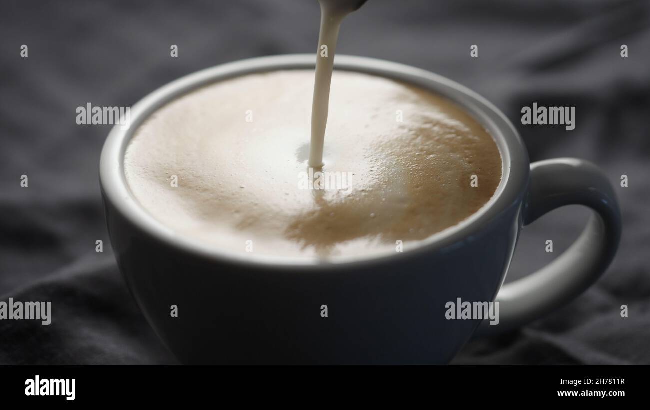 pour steamed milk into white cup making cappuccino, wide photo Stock ...