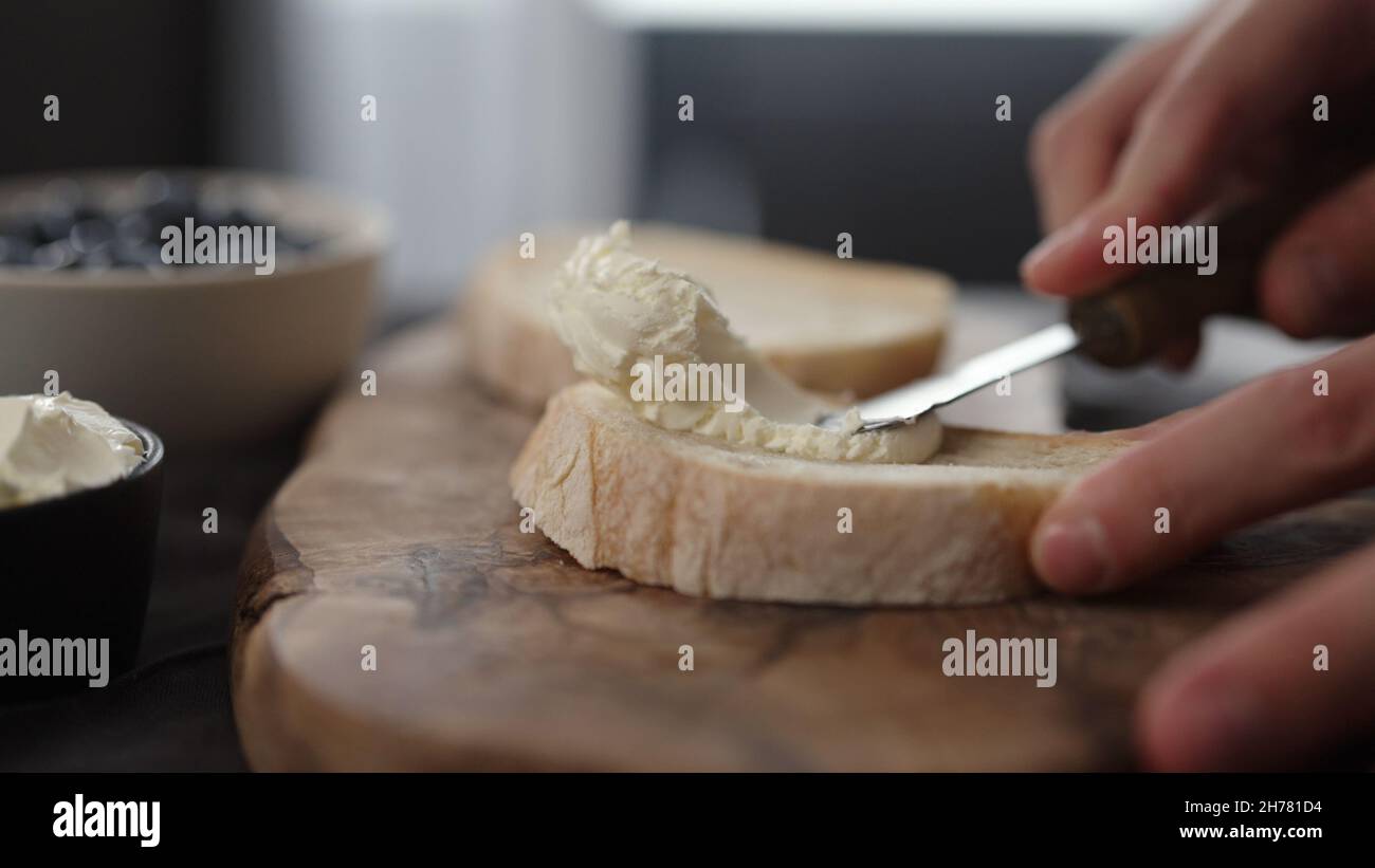 man hand spreading cream cheese on slice of ciabatta, wide photo Stock ...
