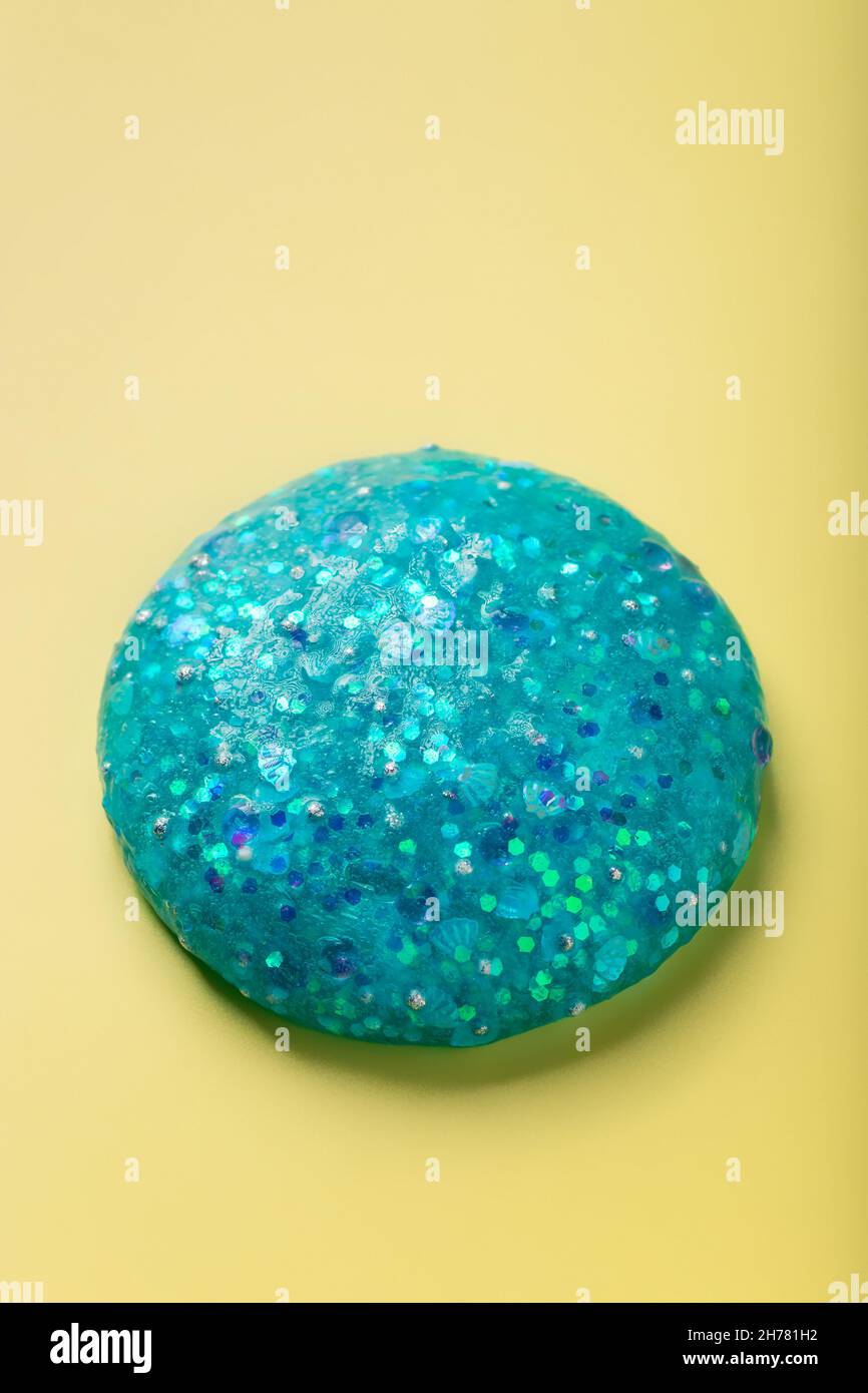 Blue glitter slime on yellow background. fun sensory toy Stock Photo ...