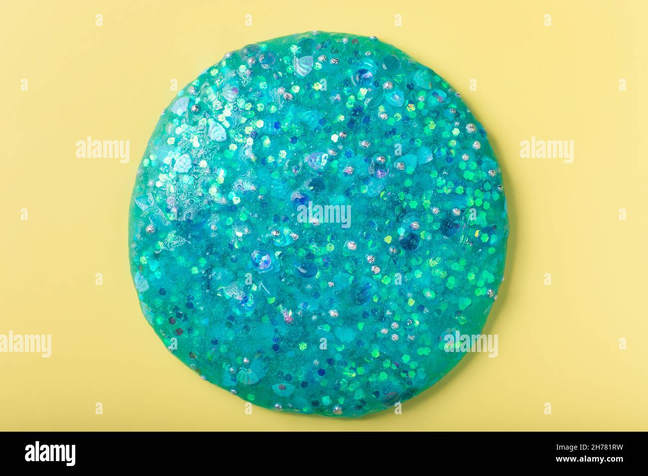 blob of blue slime with glitter on yellow background Stock Photo - Alamy
