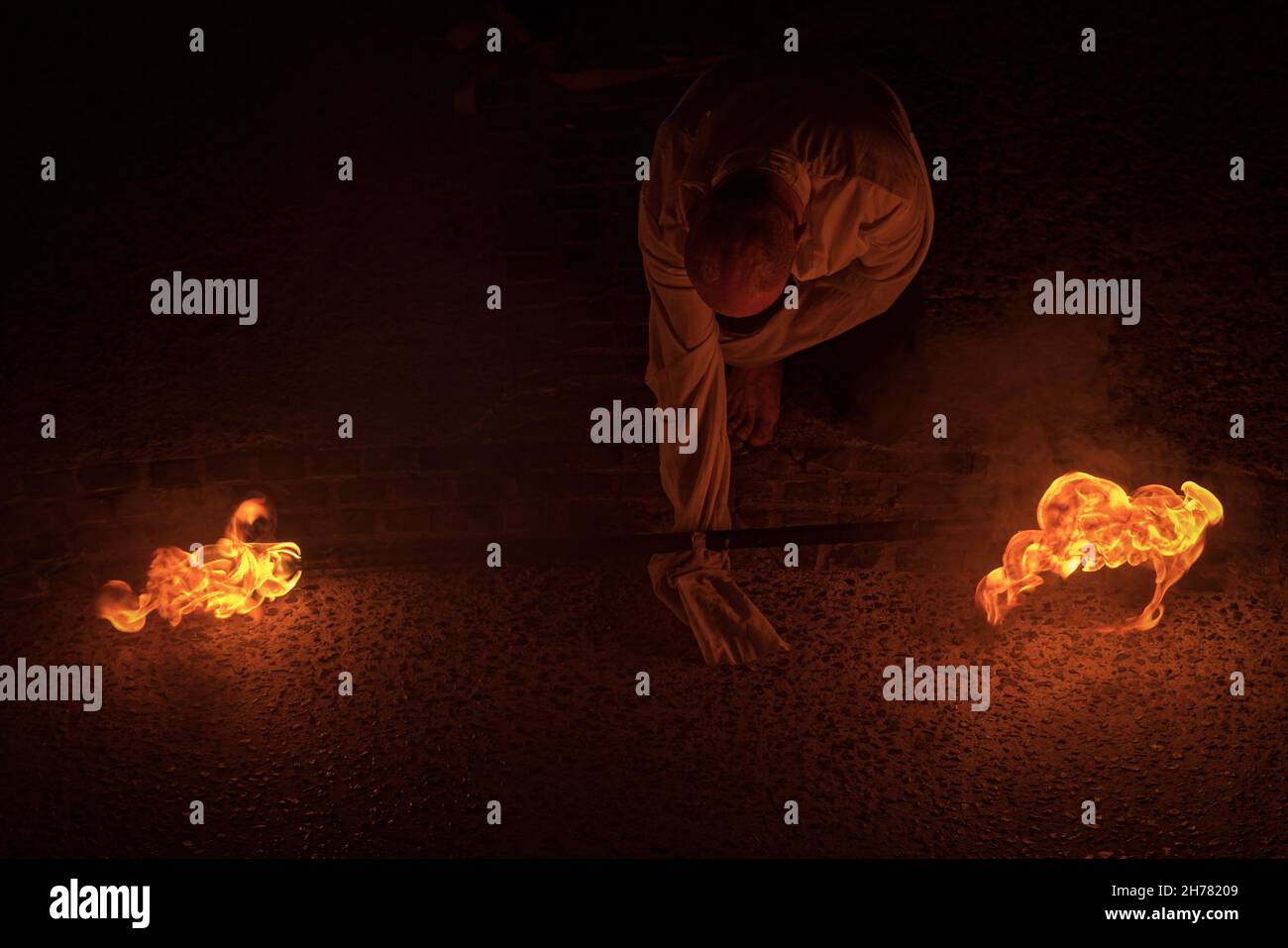 Fire performance by a street artist unknown at night with burning ...