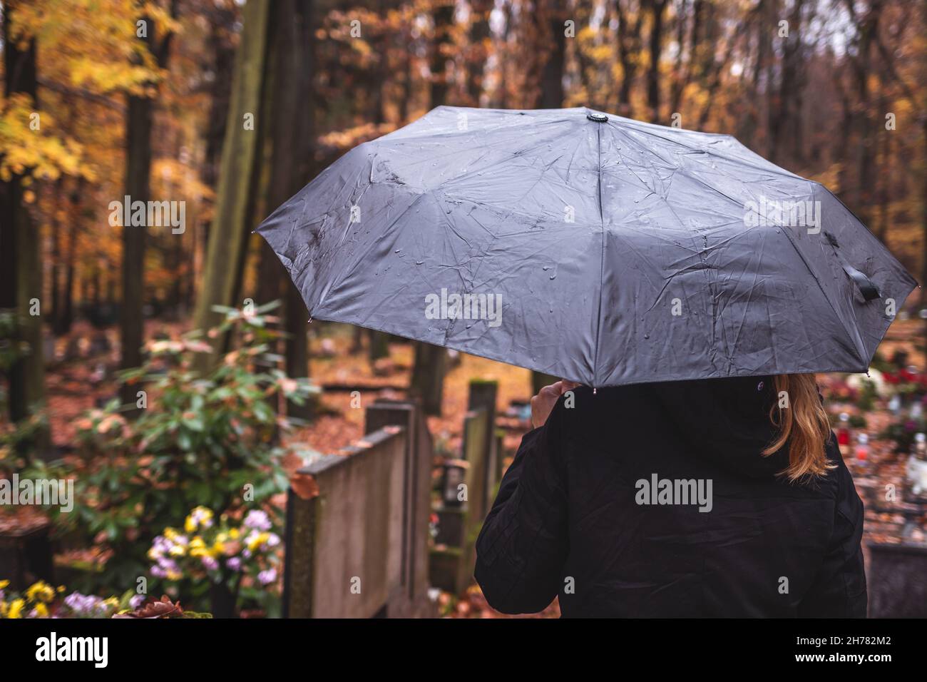 Silent grief in cemetery. Lonely sad woman mourning for dead person at ...