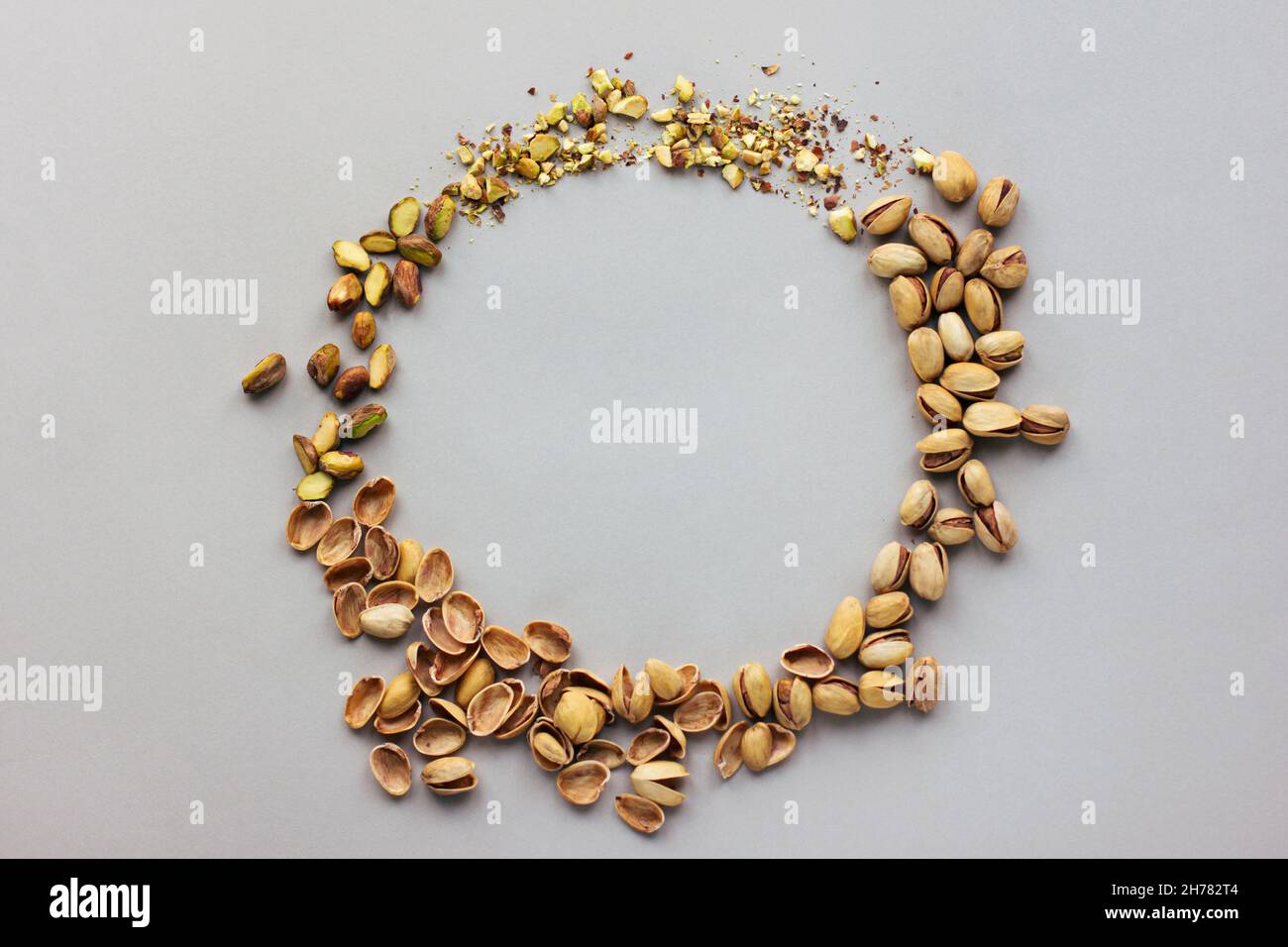 Round frame of pistachios in shell and peeled on a gray background ...