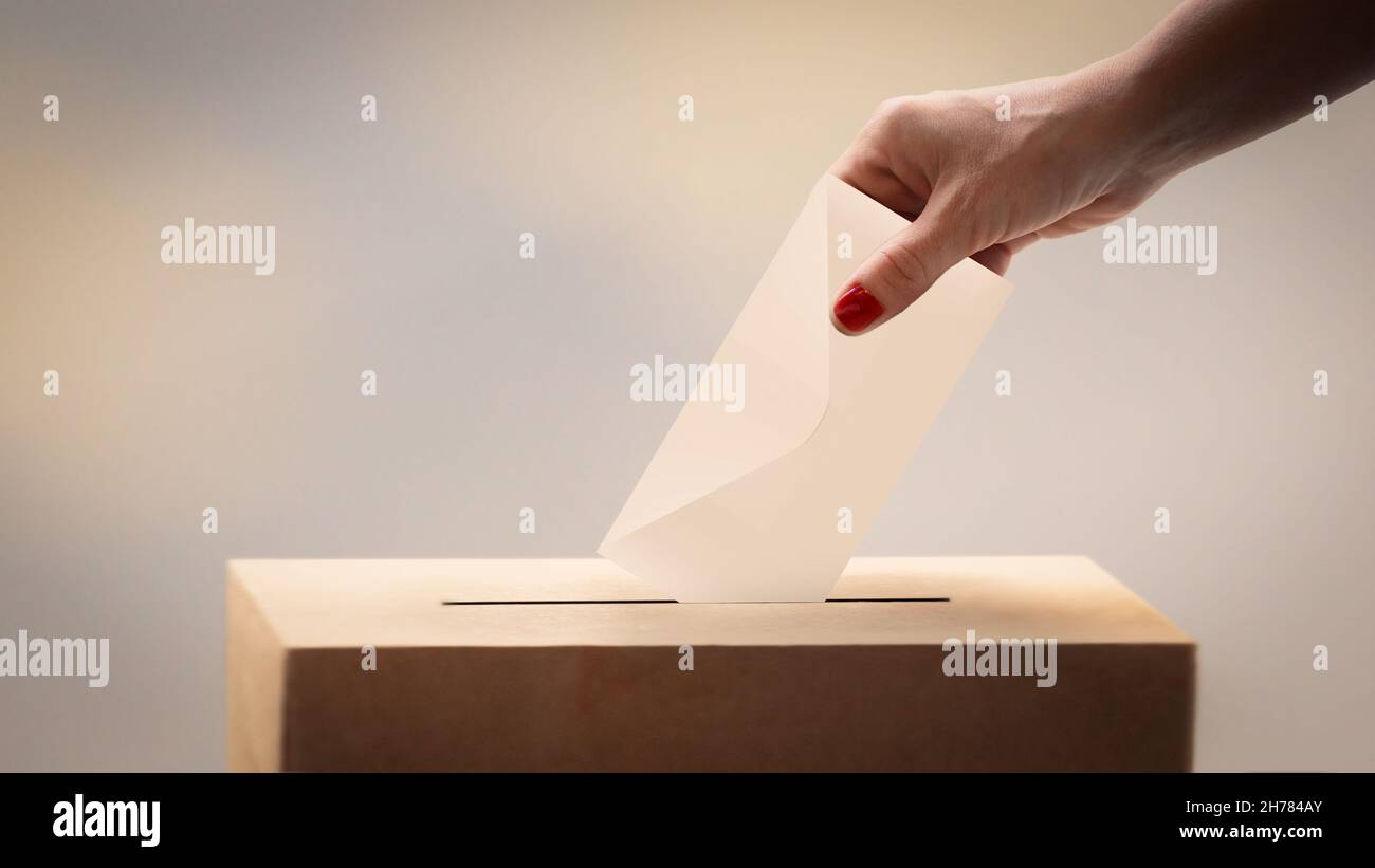 choice concept. Female voter throwing her ballot at the ballot box ...