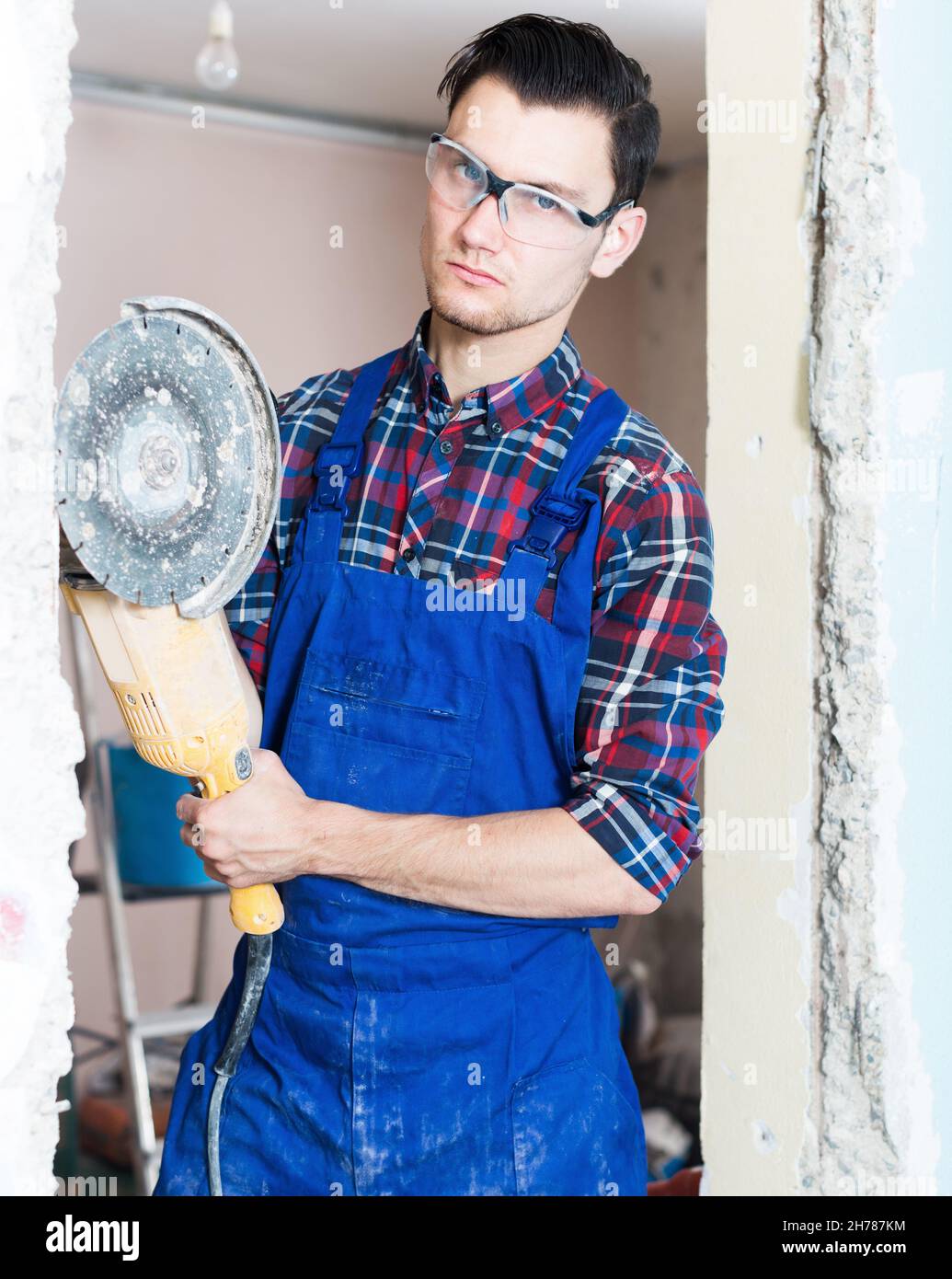 Young male workerusing professional angle grinder Stock Photo - Alamy