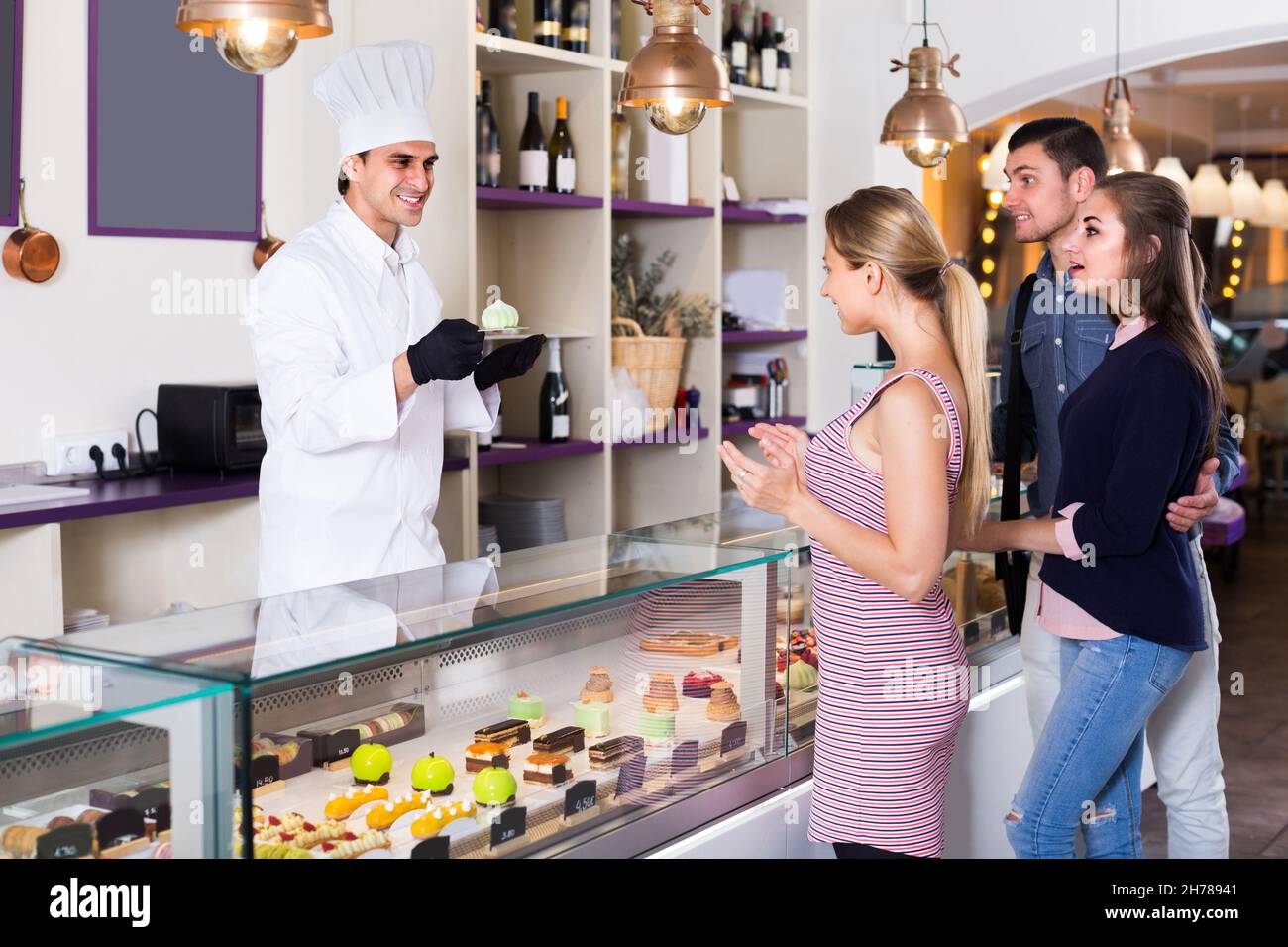 Professional baker is offering delicious cakes from showcase Stock ...